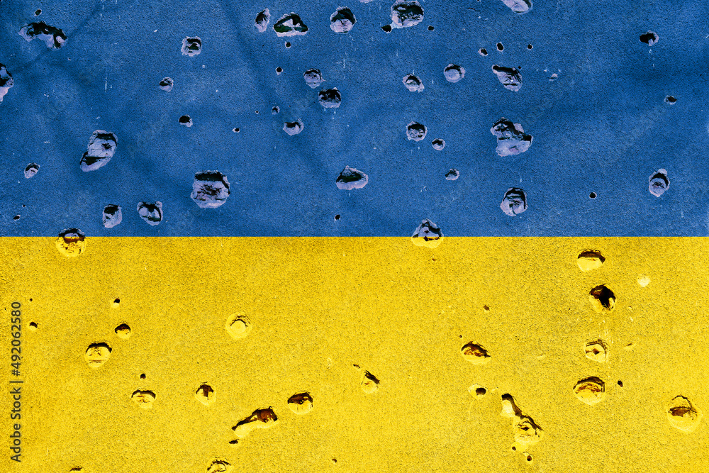 Ukrainian flag with bullet holes on the facade of a residential ...