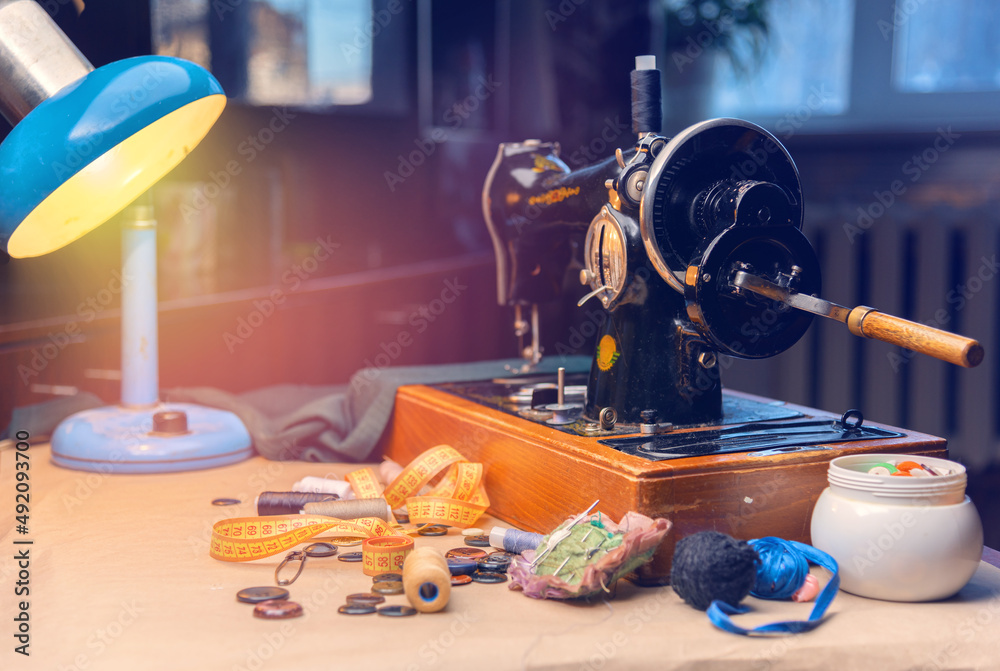 An old retro sewing machine with a place and items for a dressmaker ...