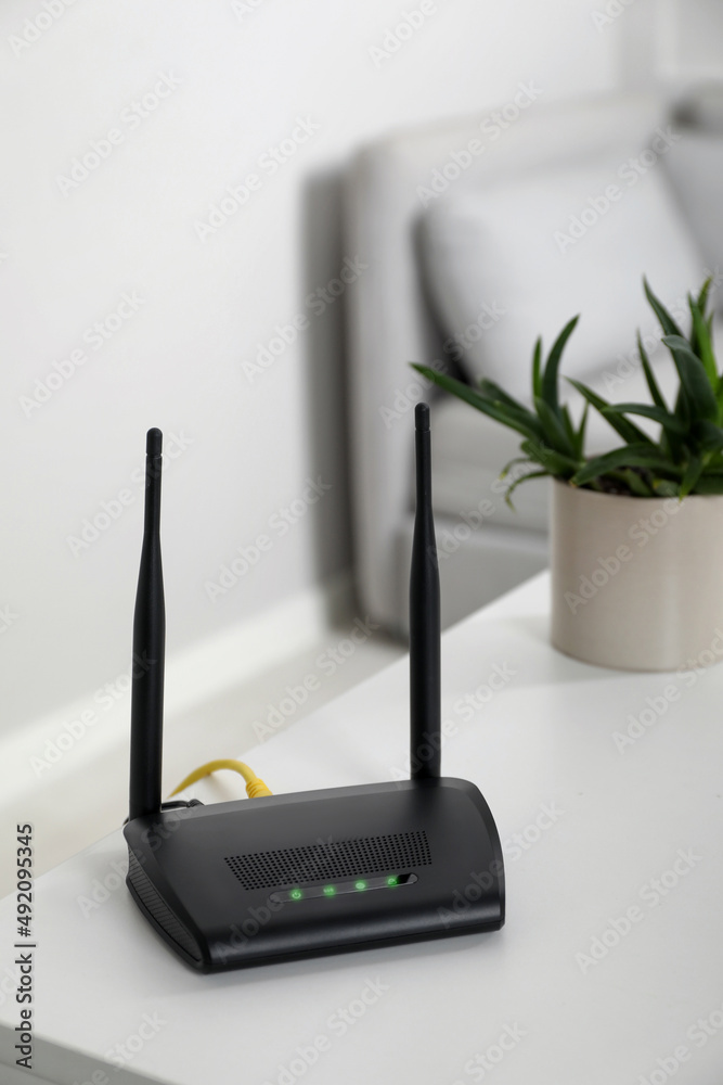 Modern Wi-Fi router on white table in room Stock Photo | Adobe Stock