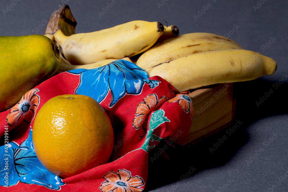 Tropical fruits: bananas, papaya, orange and a piece of Cheetah fabric ...