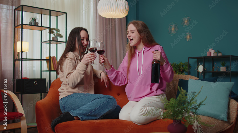 Happy girls friends siblings clinking glasses of red wine cheering and ...