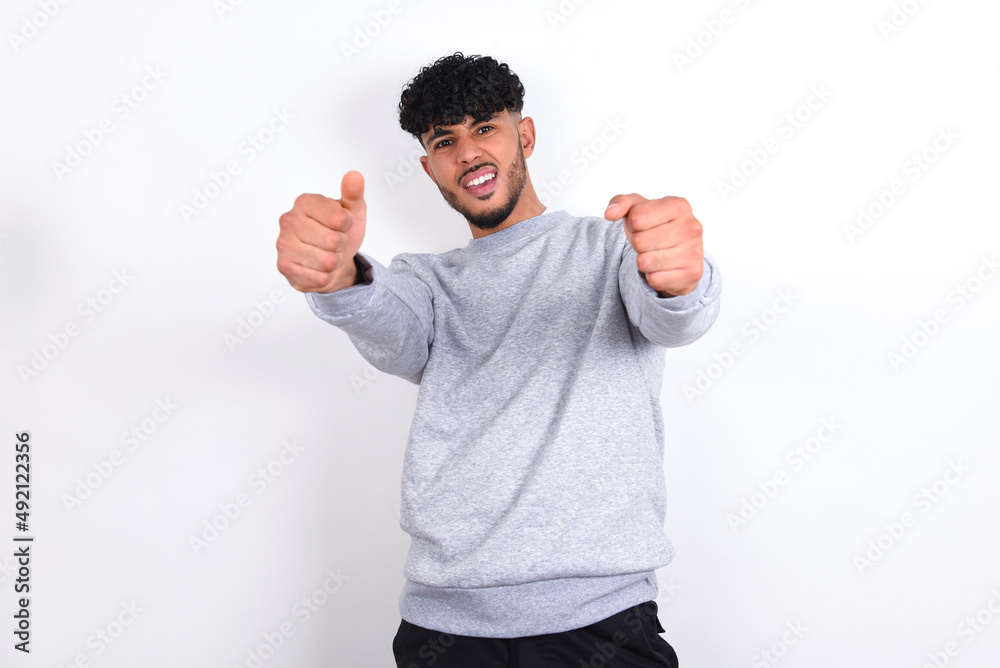 young arab man with curly hair wearing sport sweatshirt over white ...