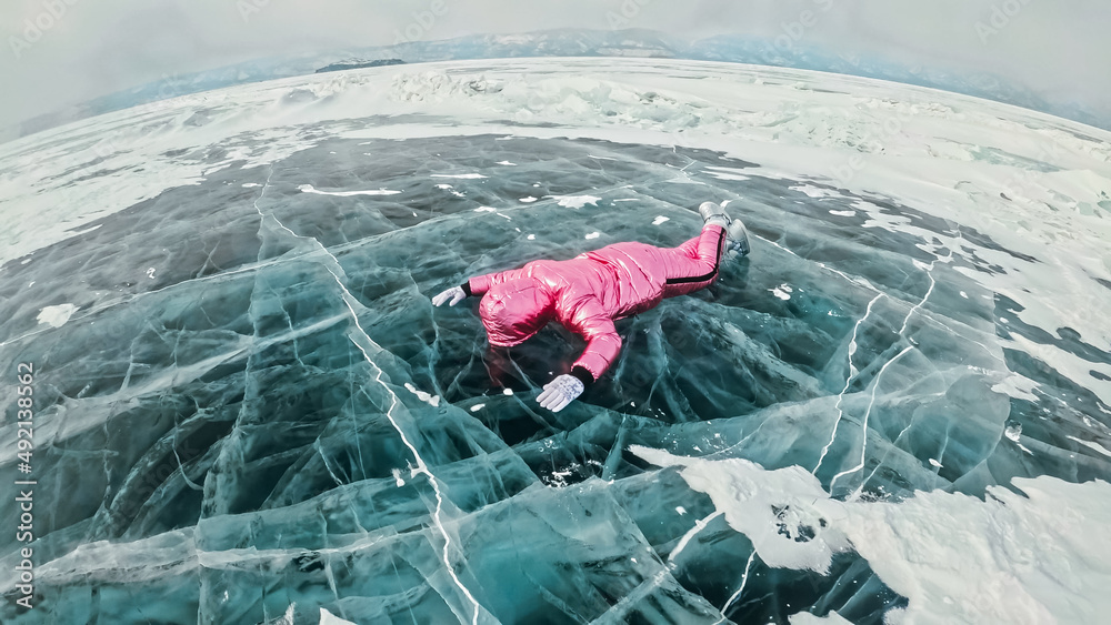 Girl walking on cracked ice of frozen lake Baikal. Woman traveler ...