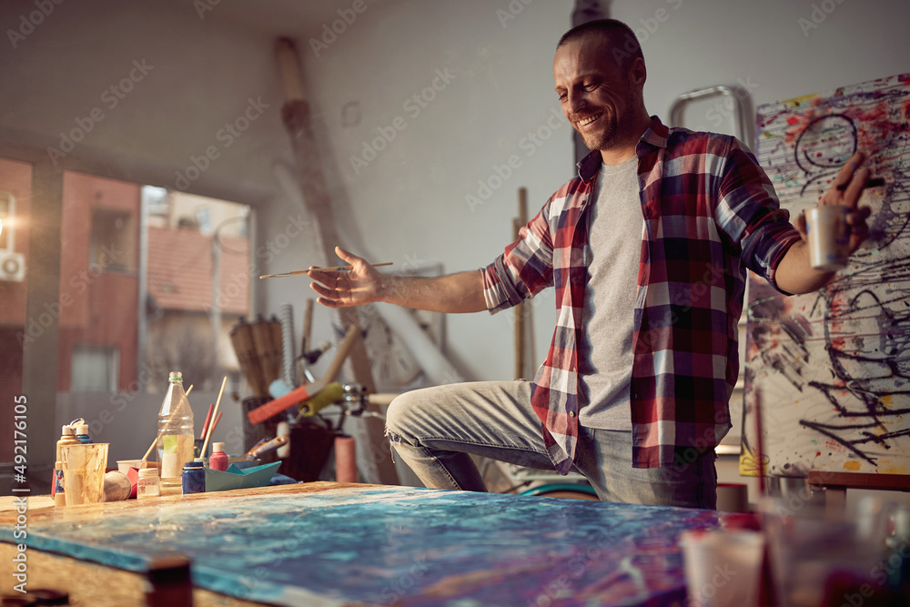 Smiling painter at workspace. Artist working on new paint. Stock Photo ...