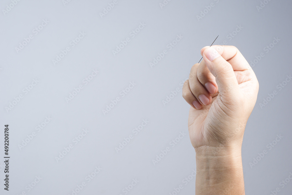 hand holding sewing needle Stock Photo | Adobe Stock