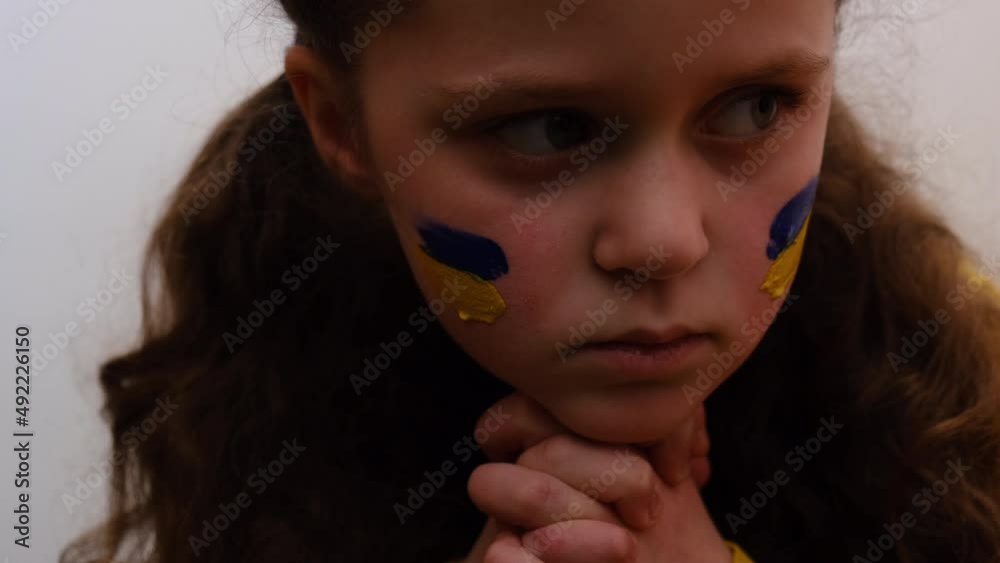 Close up portrait of upset sad Ukrainian little girl child with police ...