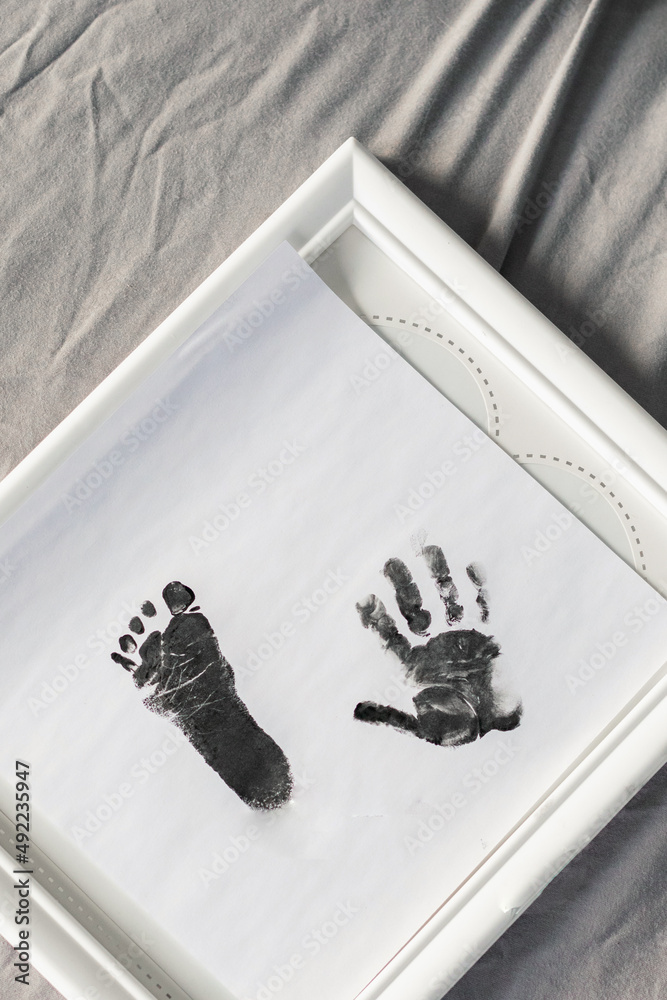 Baby footprints on white paper. Black footprint. The process of ...