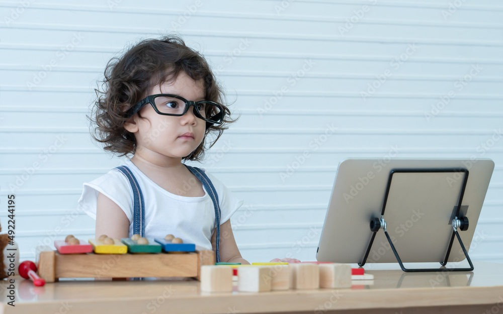 Little Caucasian nerd kid girl wearing glasses online learning on ...