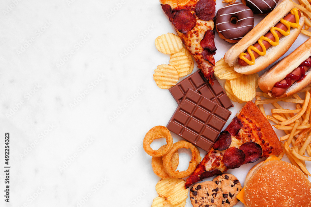 Junk food side border over a white marble background. Variety of take ...