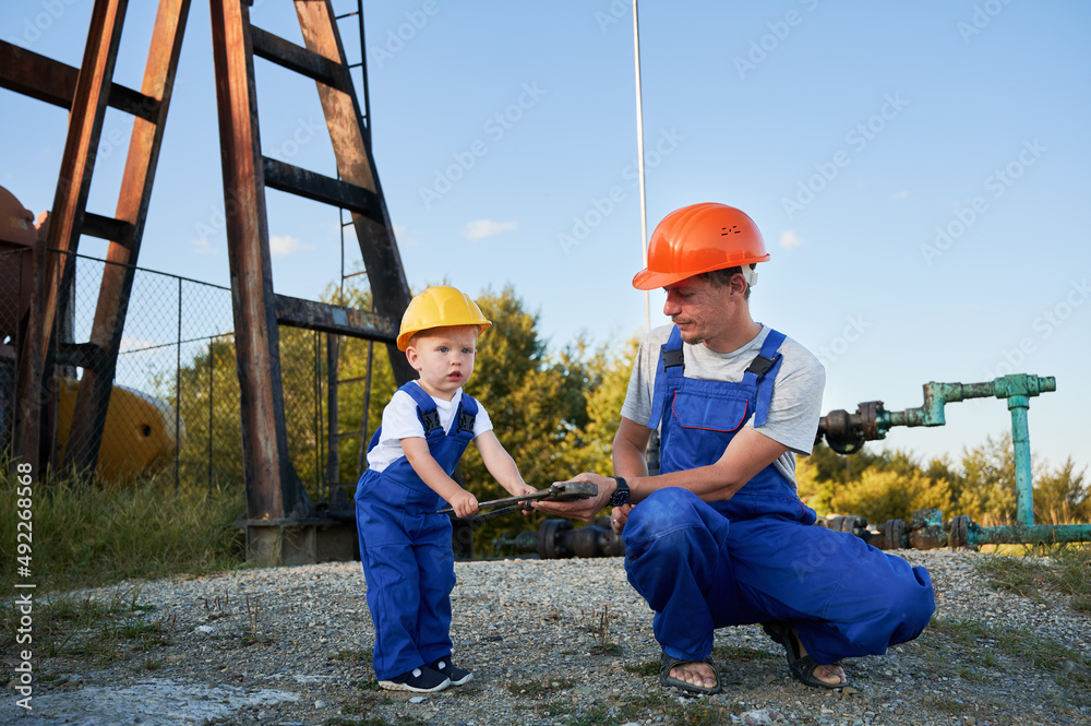 Engineer father introducing his son to work tool. Adult man and ...