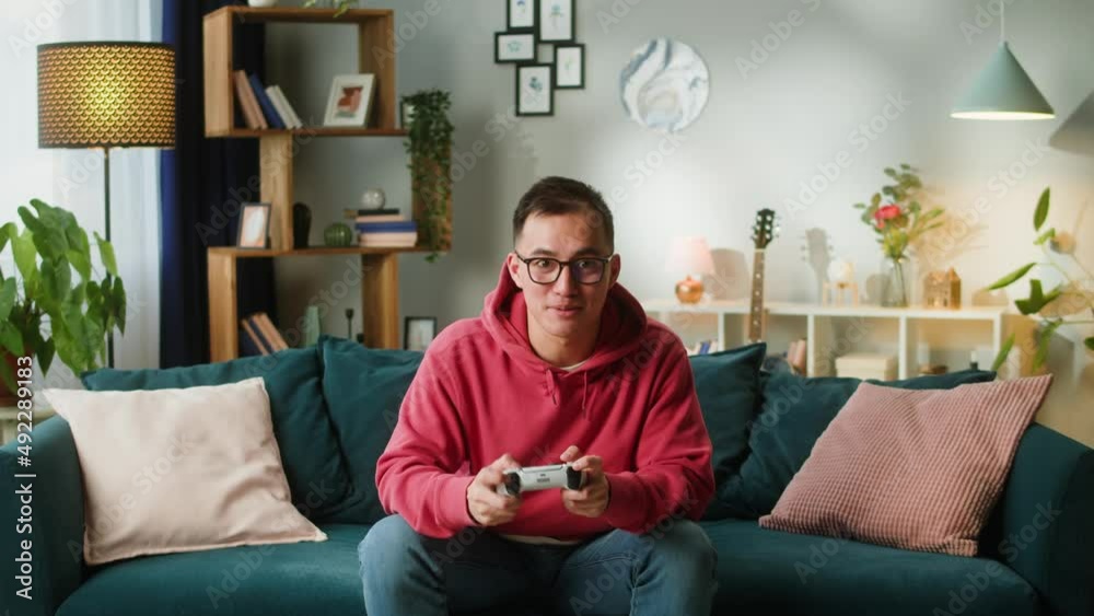 Asian man playing video games on modern console. Happy young Korean guy ...