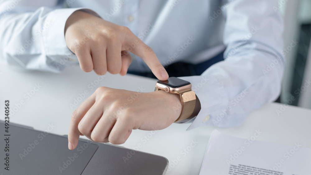 Businesswoman uses a smartwatch to make reminders or keep a small note ...