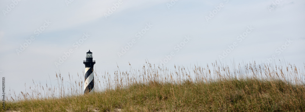The famous and historic Cape Hatteras Lighthouse seen over the dunes on ...