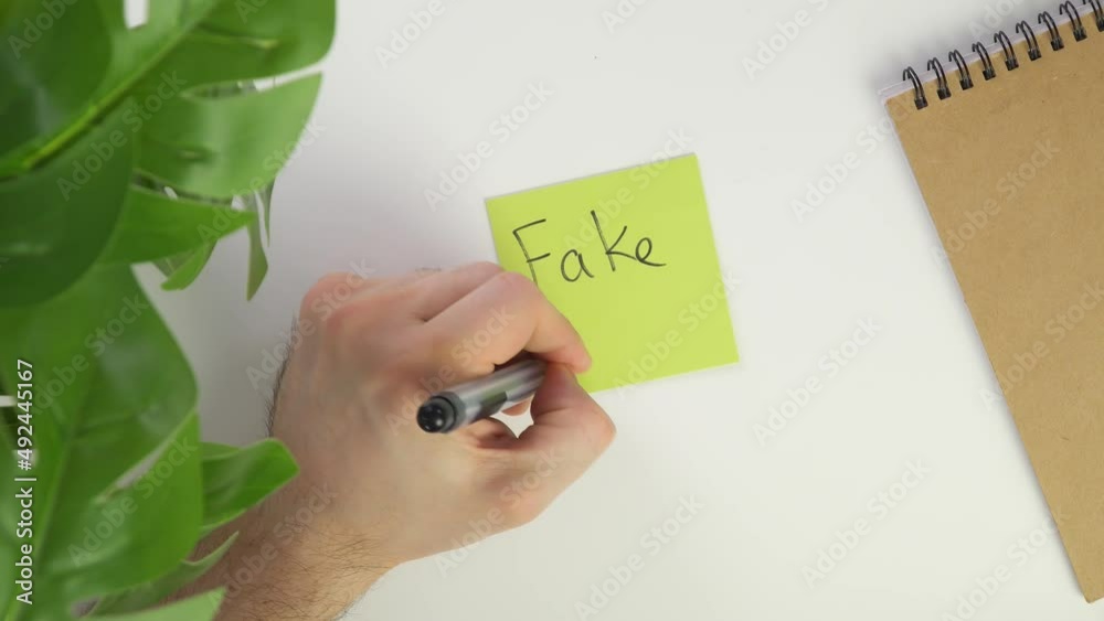 Fake news text on paper. Top view write with a pen on a sticker. Put a ...
