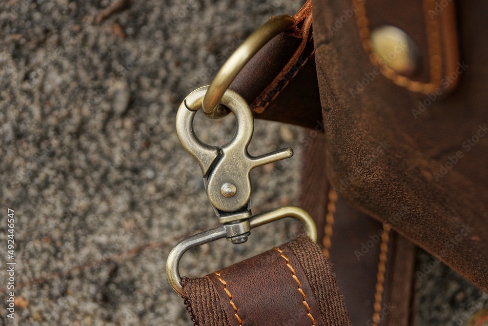 gray metal latch carabiner with brown leather harness on backpack Stock ...