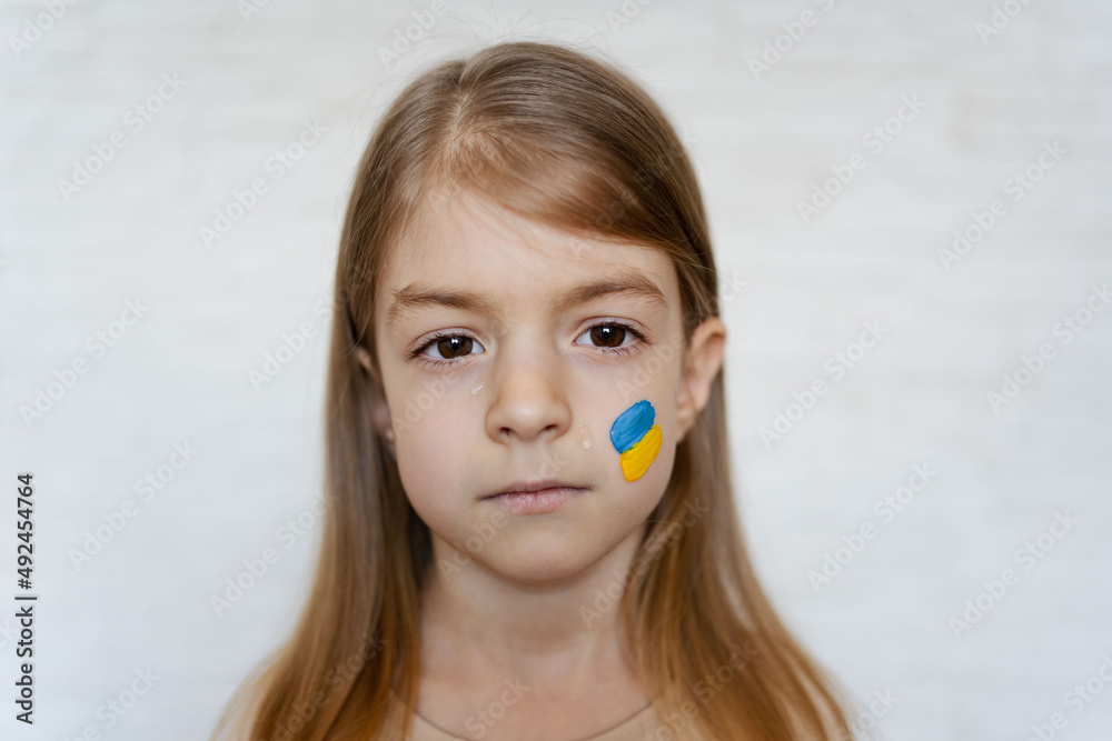 portrait of a afraid girl, a child crying, painted on her cheek the ...
