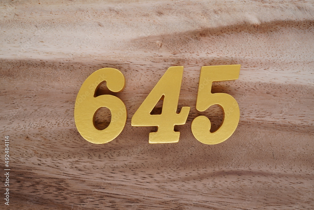 Golden Arabic numerals on a real brown and white wooden floor number ...