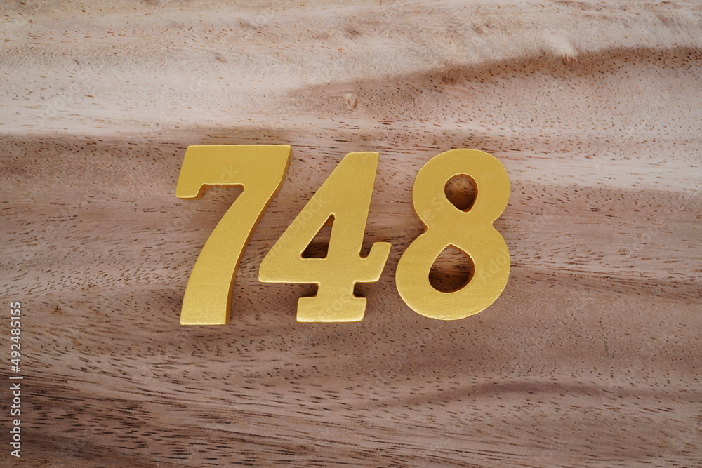 Golden Arabic numerals on a real brown and white wooden floor number ...
