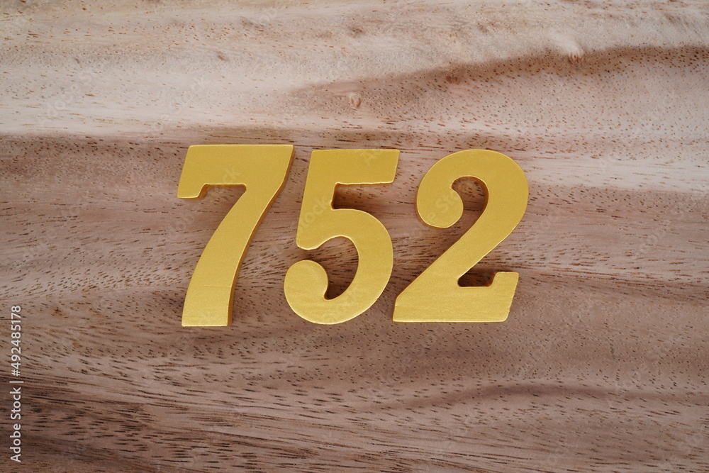 Golden Arabic numerals on a real brown and white wooden floor number ...