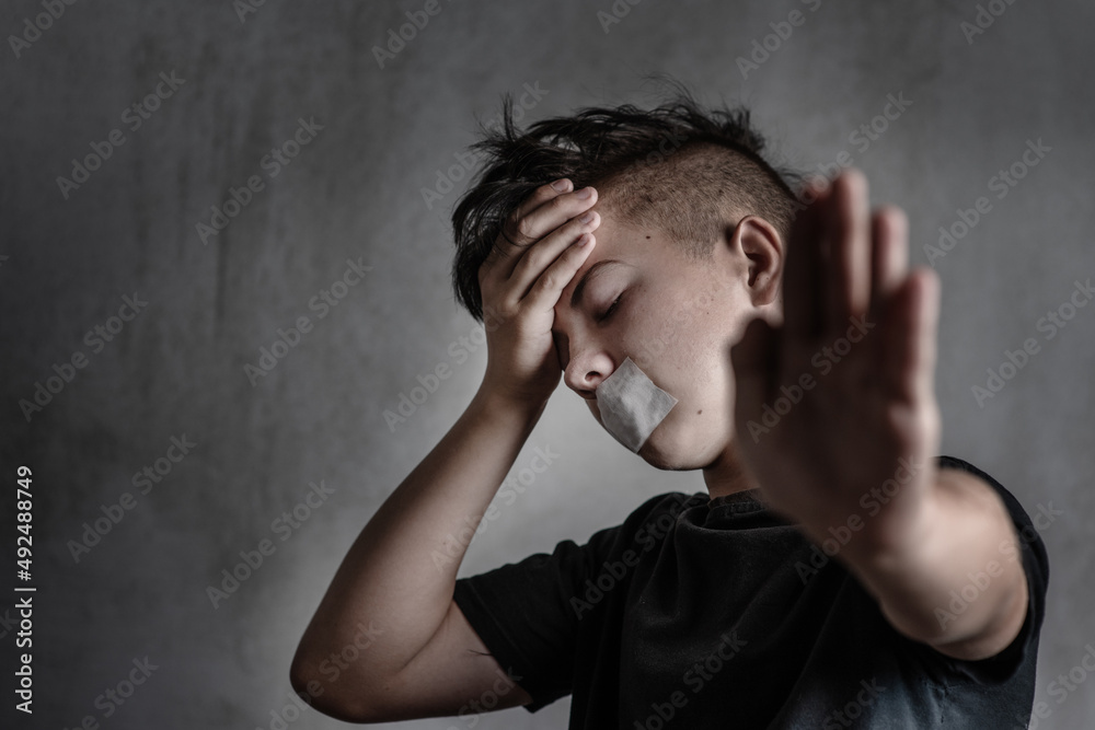 Sad teen boy covered his mouth. Problems of suppression of emotional ...