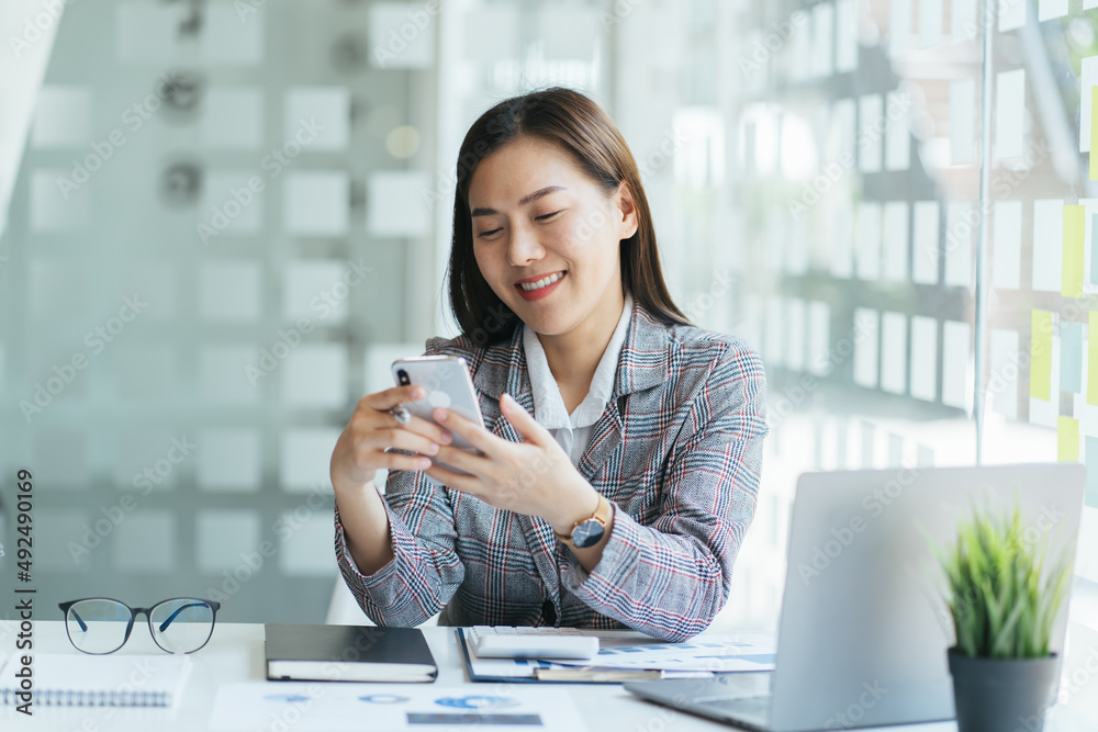 Attractive young woman checking her text messages on her mobile phone ...
