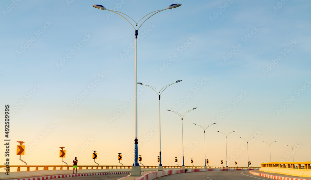 Curve road with street lamp pole and yellow curve traffic sign. Back ...