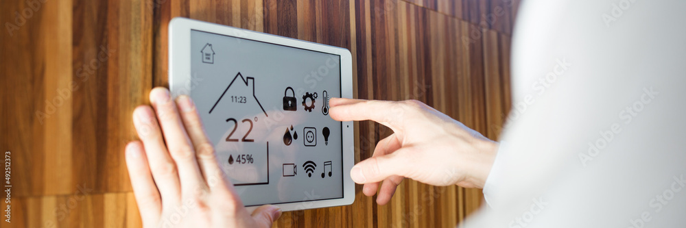 man controls smart home devices using digital tablet with launched ...