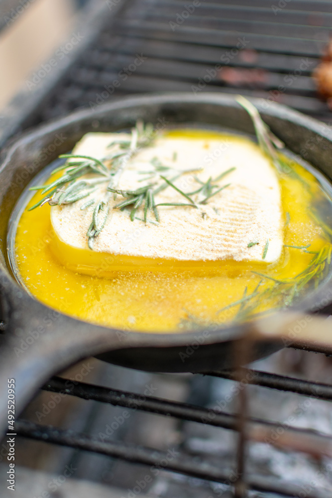 mantequilla derretida con romero en sarten de hierro sobre la parrilla ...