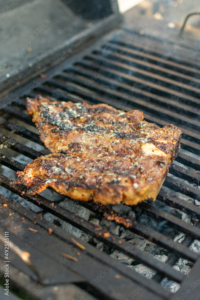 corte de res T- bone. T bone corte en el asador corte al carbón manos ...