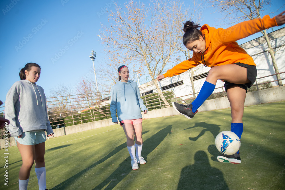 Young female athletes playing football. Healthy Caucasian girls in ...
