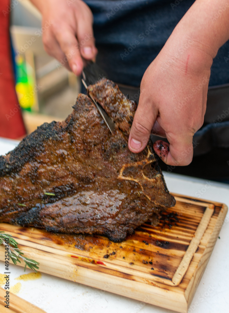 corte de res T- bone. T bone corte en el asador corte al carbón manos ...