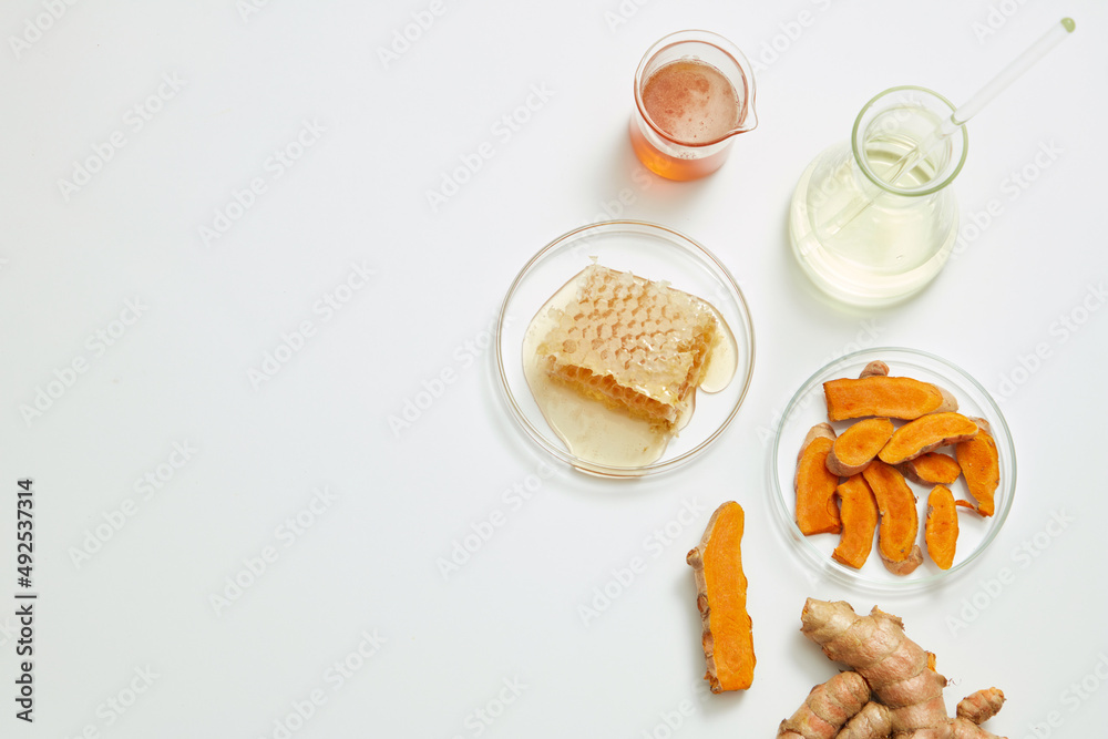 Honey and turmeric decorated with transparent podium and beaker test ...