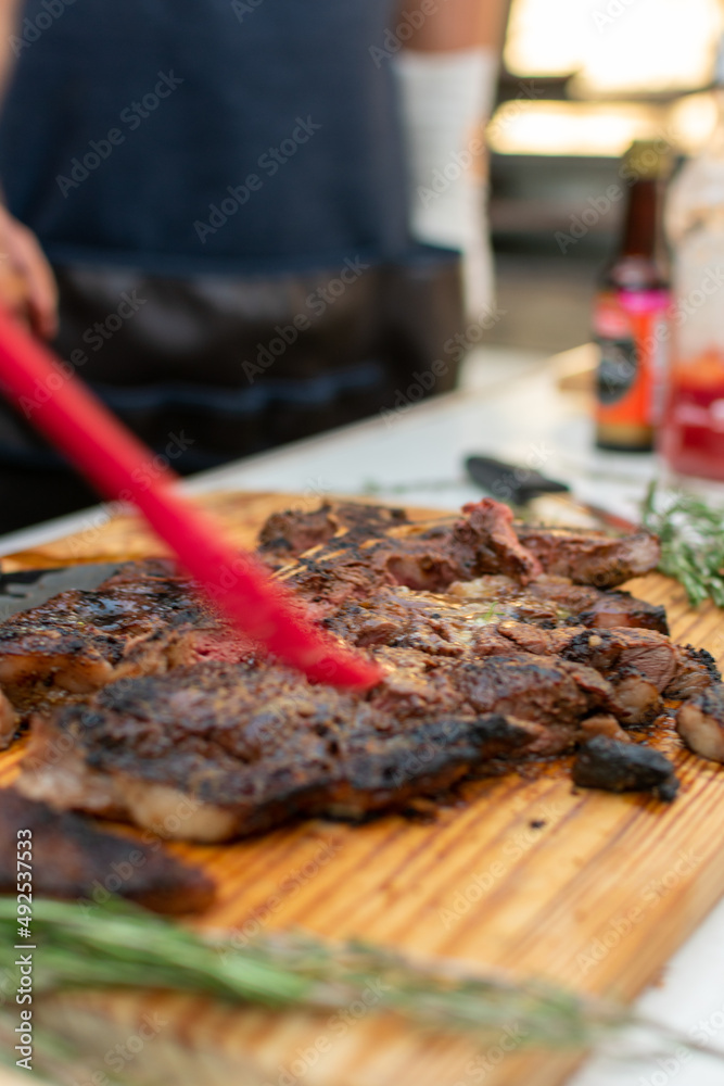 corte de res T- bone. T bone corte en el asador corte al carbón manos ...