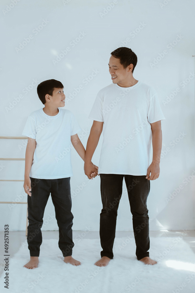 Asian young father in white t shirt and his son in white t shirt are ...