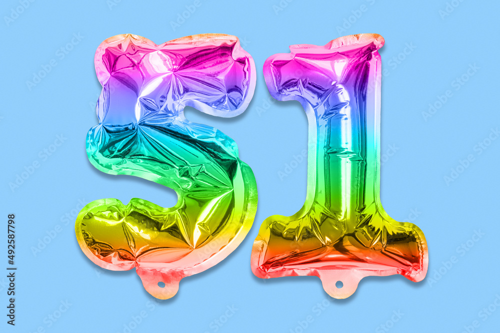 Foto de Rainbow foil balloon number, digit fifty one on a blue ...