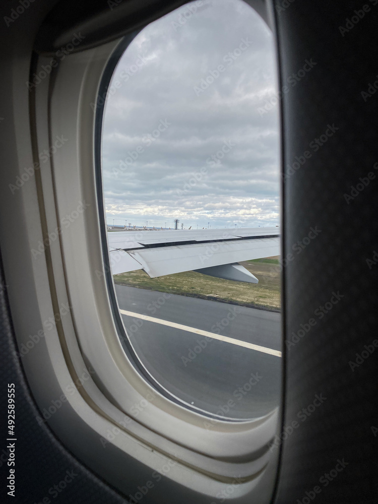 Airplane window seat view of airplane wing and airport runway with a ...