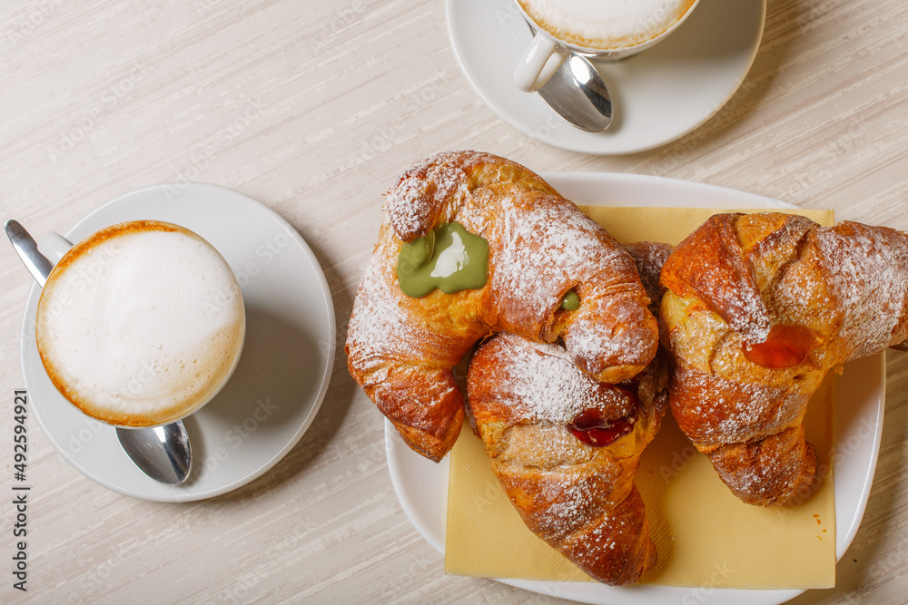 Tavolo di un bar a Colazione fotografato dall'alto con due cappuccini e ...