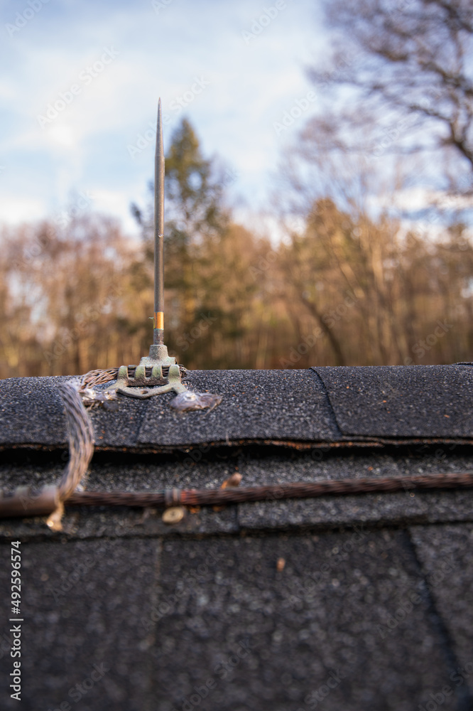 Close up of lighting rod mounted on a residential roof to ground the ...