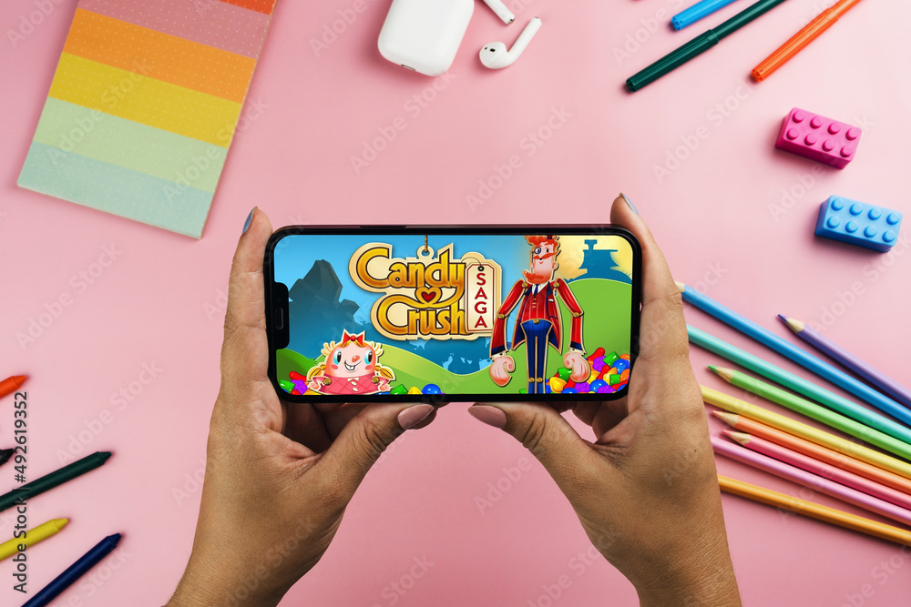 Girl holding a smartphone with Candy Crush Saga mobile game app on the ...
