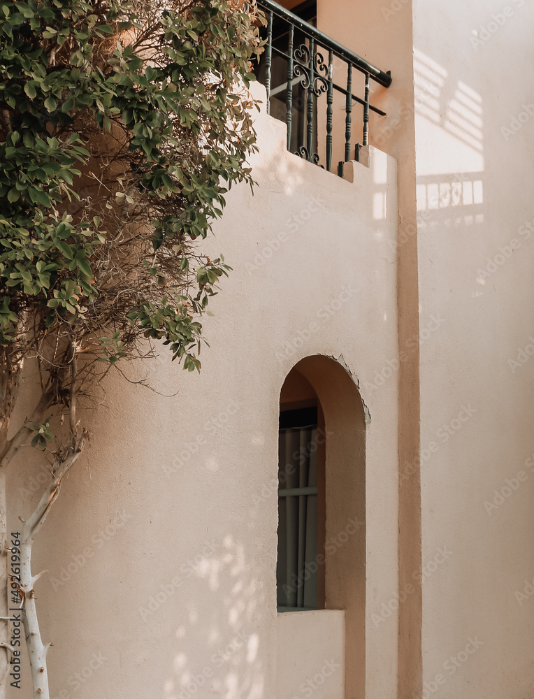 The wall of the building with the arch-shaped window and a balcony ...