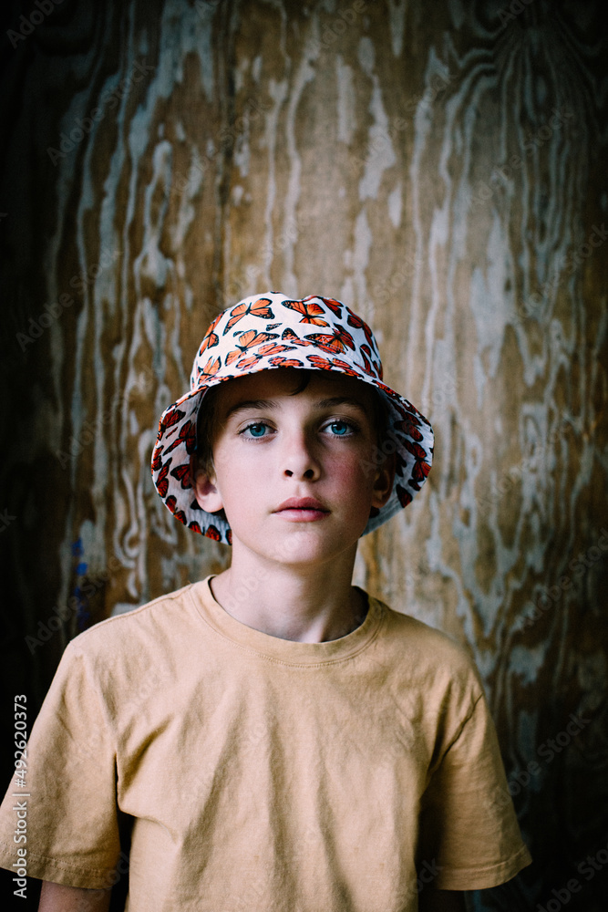 Foto de Teen Boy with Butterfly Bucket Hat Poses for a solo Portrait do ...
