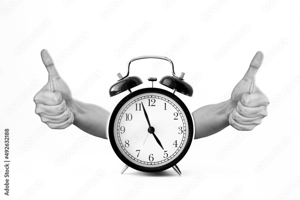 Black alarm clock with two hands thumbs up isolated on white background ...