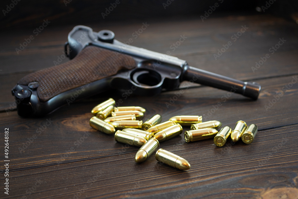 Historic Luger P08 Parabellum handgun and shiny 9 mm bullets on wooden ...