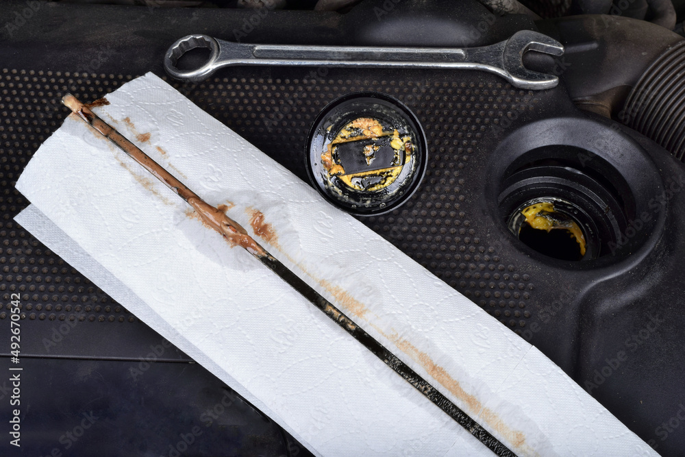 The thick, greasy yellow motor oil under oil cap as signs and symptom ...