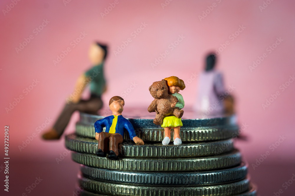 Miniature people. Brother and sister sitting alone. Parents in the ...