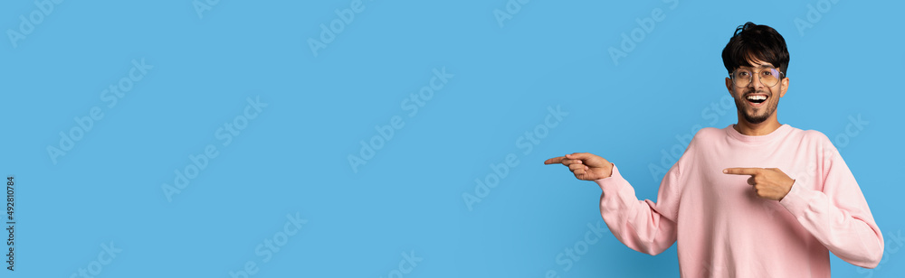 Positive indian guy pointing at copy space on blue, panorama Stock ...