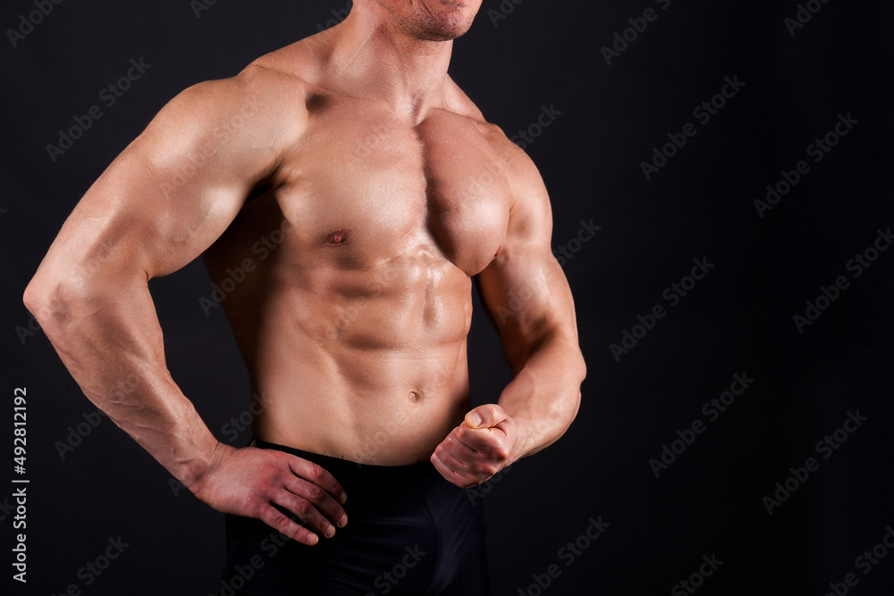 Professional bodybuilder posing over isolated black background. Studio ...