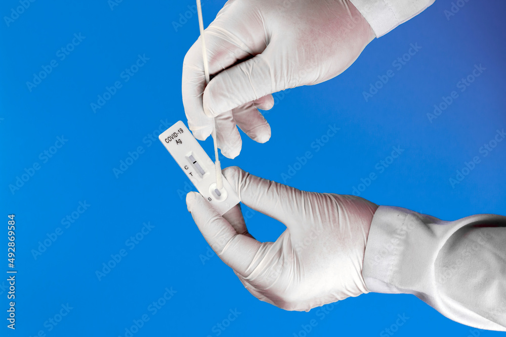 Doctor hand holding Covid -19 rapid antigen test cassette and nasal ...