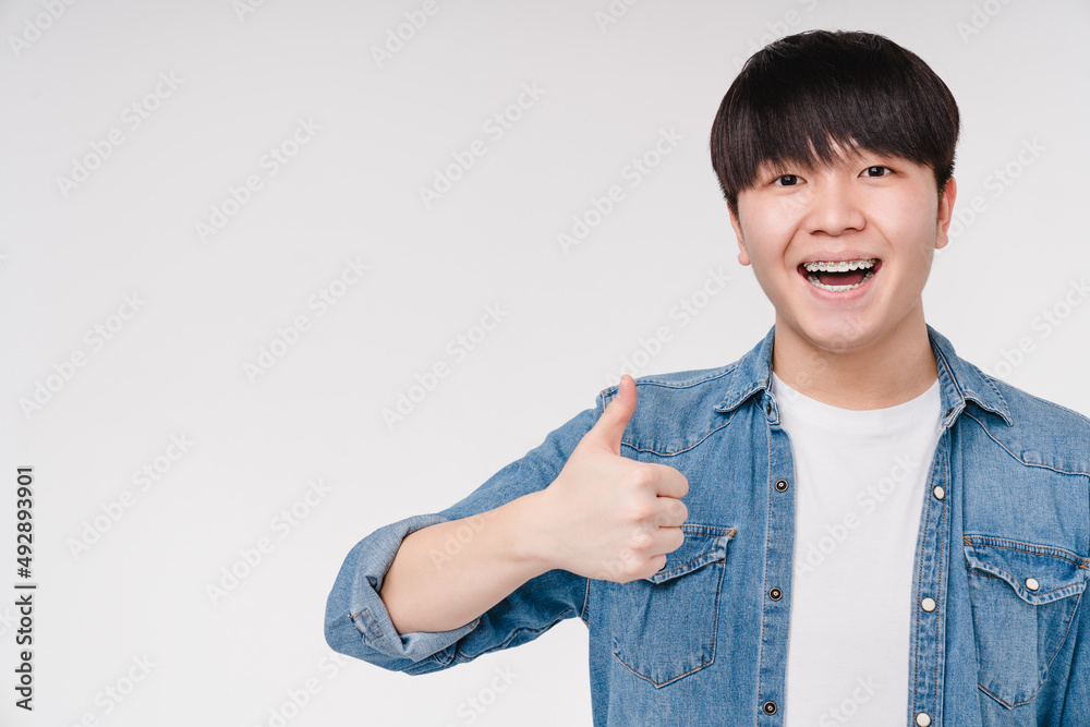 Happy young asian korean boy man student showing thumb up, saying yes ...