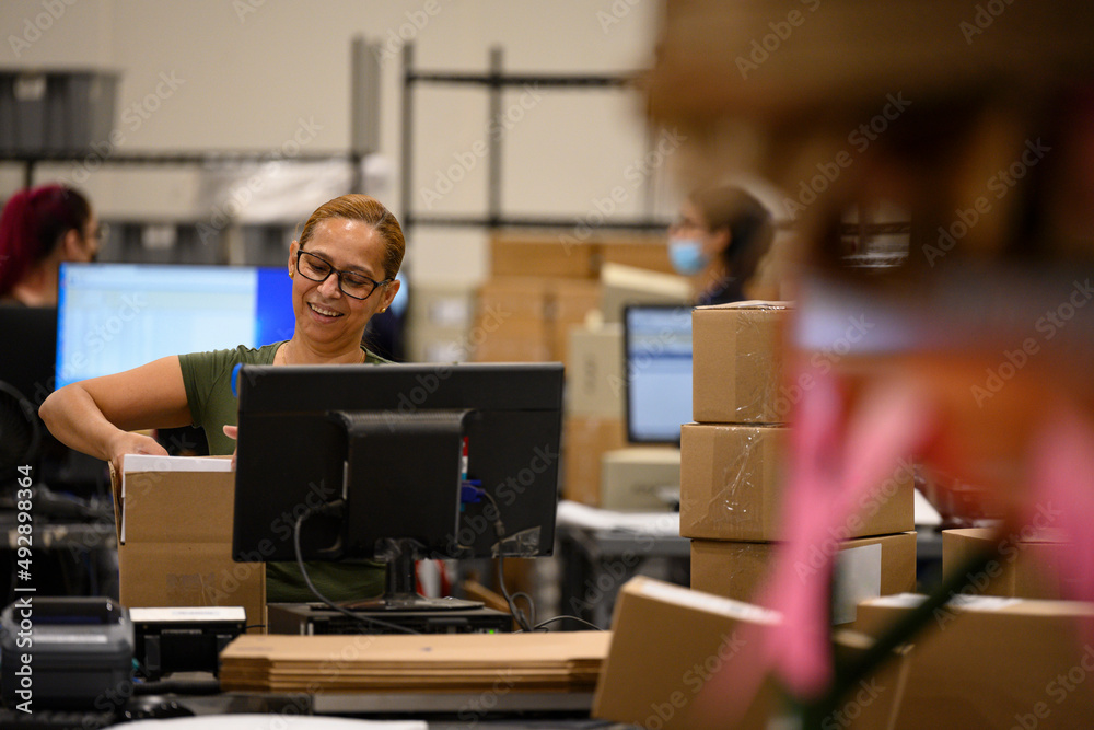 Workstation at ecommerce facility with worker Stock Photo | Adobe Stock
